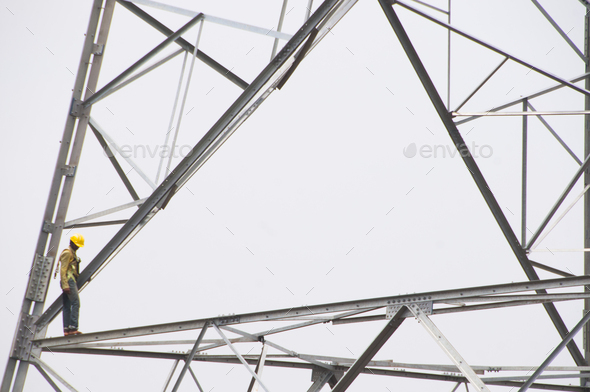 Pylon construction workers working on the top of power tower. Stock ...