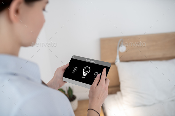 Female turning on light using a remote control Stock Photo by Zinkevych_D