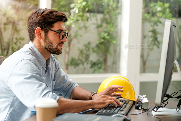 Handsome business man with casual cloth is typing keyboard to add data ...
