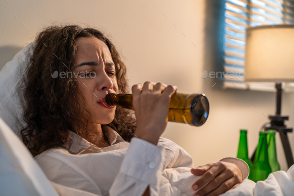 Drunk Latino woman hold beer bottle, and crying feel hangover crying in ...