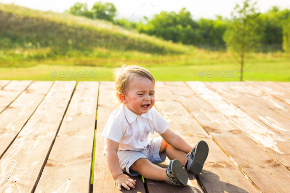 Portrait of cute little baby boy crying outside Stock Photo by Satura_