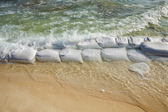 Sandbags in rows at the water's edge to prevent erosion of the beach ...