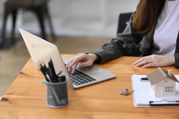Real estate agent working with laptop computer in her office room ...
