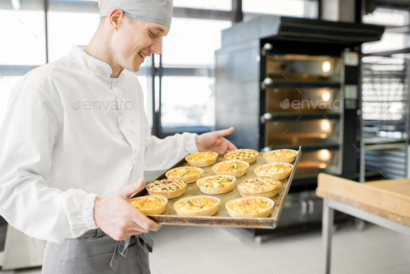 Baker with buns at the manufacturing Stock Photo by RossHelen | PhotoDune