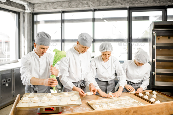 Bakers making buns at the manufacturing Stock Photo by RossHelen ...