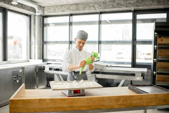 Baker filling buns at the manufacturing Stock Photo by RossHelen ...