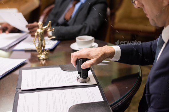 Hand of director of company putting stamp on document Stock Photo by ...