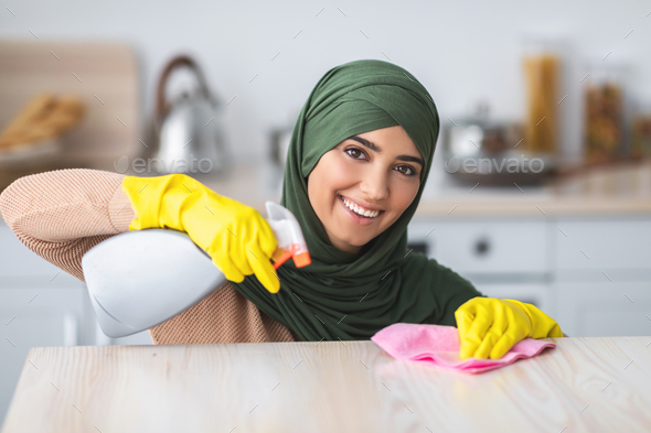 Cheerful young muslim woman cleaning dining table at kitchen Stock ...