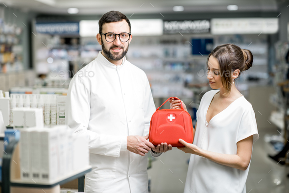 Pharmacist with client and first aid kit in the pharmacy Stock Photo by ...