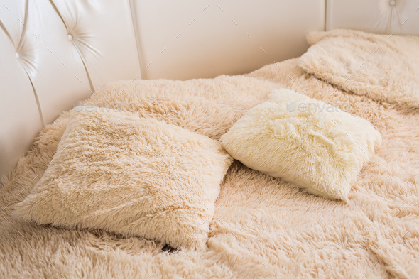 Beige fluffy pillows on the bed in cozy bedroom, interior design ...