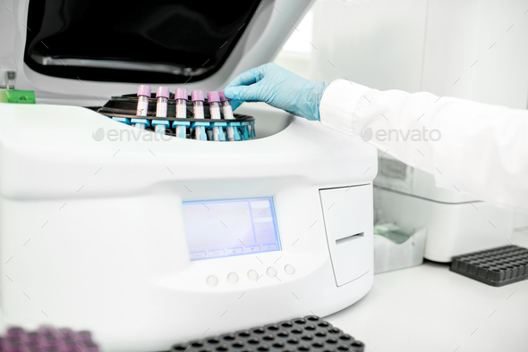 Putting test tubes into the holder of analyzer machine Stock Photo by ...