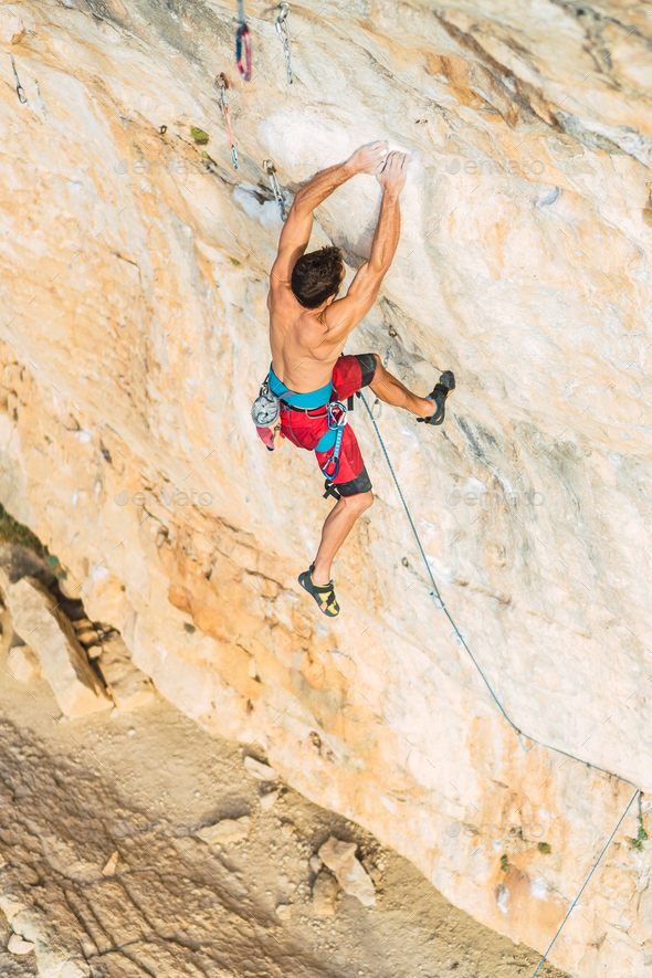 Aerial view from above of the back of a man climbing a rock formation ...