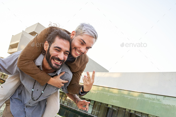 Happy gay couple man embrace in love outdoors. Cheerful LGTB people ...