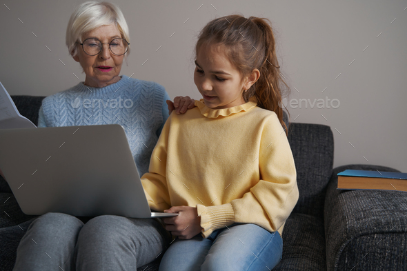 Intent child and grandma watching laptop screen at home Stock Photo by ...