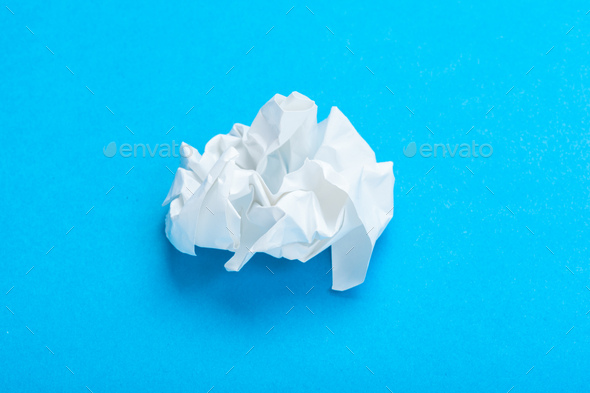 Wadded paper balls on a blue background Stock Photo by FabrikaPhoto
