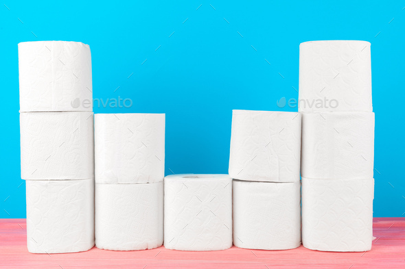 Toilet paper stack on bright blue background Stock Photo by FabrikaPhoto