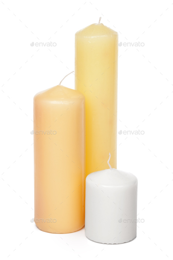 different sized candles on a white background Stock Photo by FabrikaPhoto