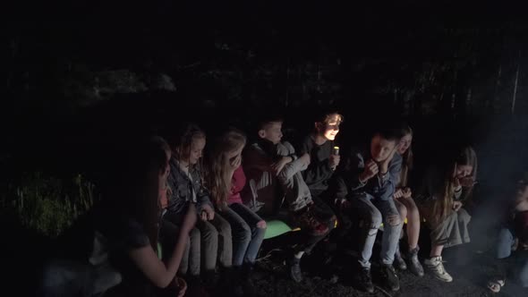 Teenager Telling Scary Story Using Flashlight on Face., Stock Footage