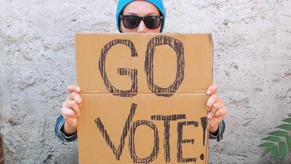 Woman shows cardboard Go Vote sign Voting balloting polling Political ...