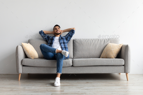 Man having rest at home on the couch Stock Photo by Prostock-studio