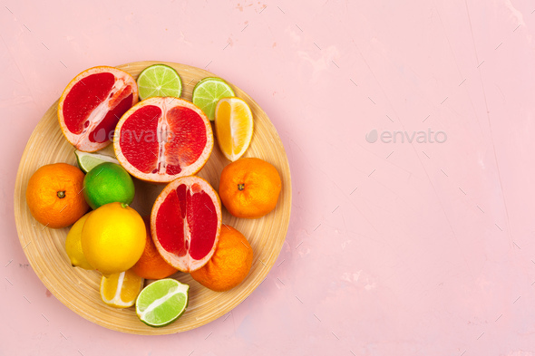 Bowl of citrus fruits on bright color background, flat lay, top view ...