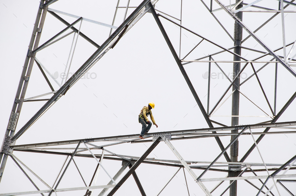 Pylon construction workers working on the top of power tower. Stock ...
