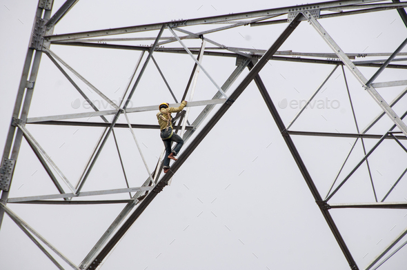 Pylon construction workers working on the top of power tower. Stock ...