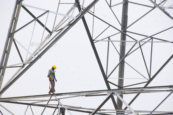 Pylon construction workers working on the top of power tower. Stock ...
