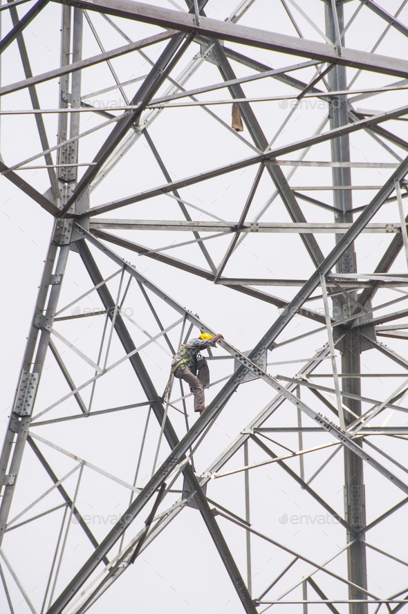 Pylon construction workers working on the top of power tower. Stock ...