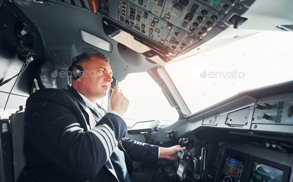 Side view. A professional pilot is in the cockpit. Conception of work ...