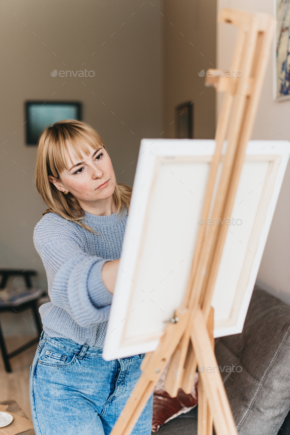 Portrait of a gorgeous female artist working on art project on her ...