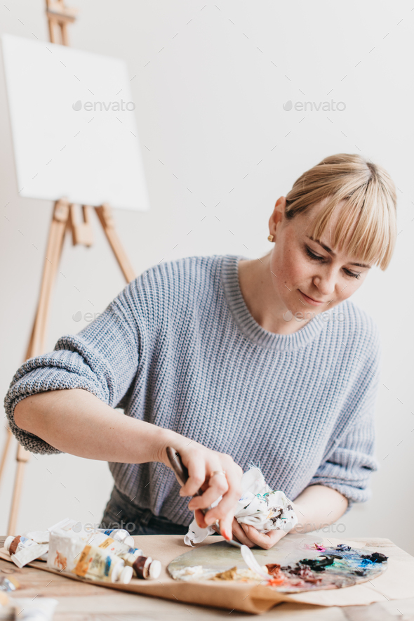 Portrait of a gorgeous female artist working on art project on her ...