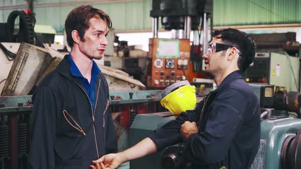 Tired Factory Workers Taking a Break and Talking to Coworker in the ...