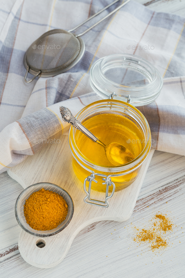 Healthy homemade Ghee or clarified butter in a jar and turmeric powder ...