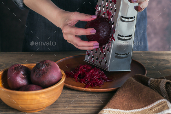 Boiled beetroot on clay plate. Woman rubbing beets on a grater. Stock ...