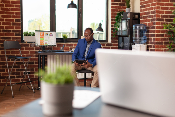 Employee using digital tablet to work on marketing strategy at ...