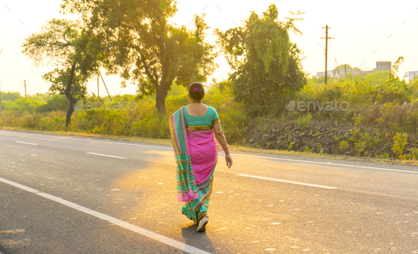 Indian woman in saree walking on at morning Stock Photo by crshelare