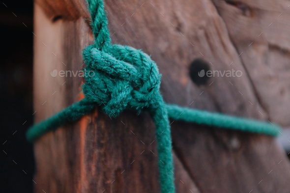 detail of a knot on a green rope tied around wooden timber Stock Photo ...