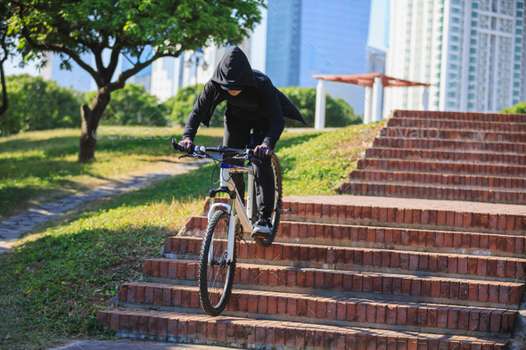 Woman free rider riding bike going down city stairs Stock Photo by lzf