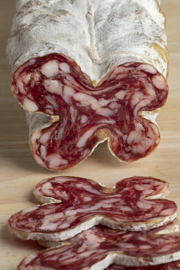 Sliced French dry sausage, Saucisson sec, on a cutting board close up ...