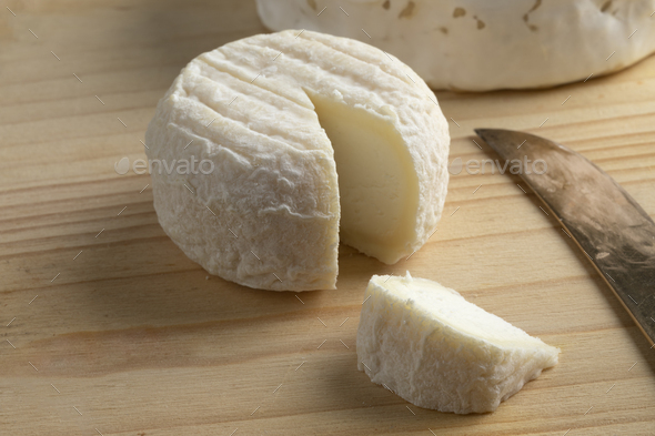 Single French goat cheese, Crottin de pays, and a piece close up on a ...