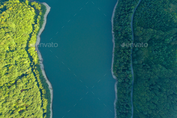Top down aerial view of big lake with clear blue water between high ...