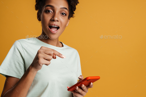 Young black woman using and pointing finger at mobile phone Stock Photo ...