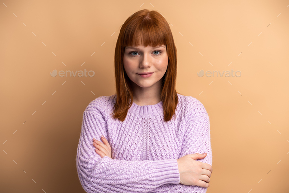 Positive ginger woman standing with crossed arms and charming smile ...