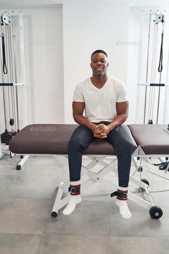 Joyous patient seated at gym looking ahead Stock Photo by Iakobchuk