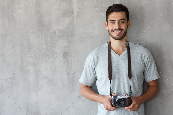 Handsome Caucasian guy pictured with camera hanging on strap on his ...