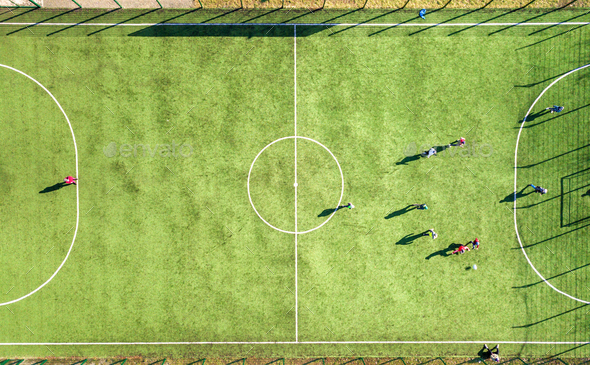 Top down aerial view of green football sports field and players playing ...