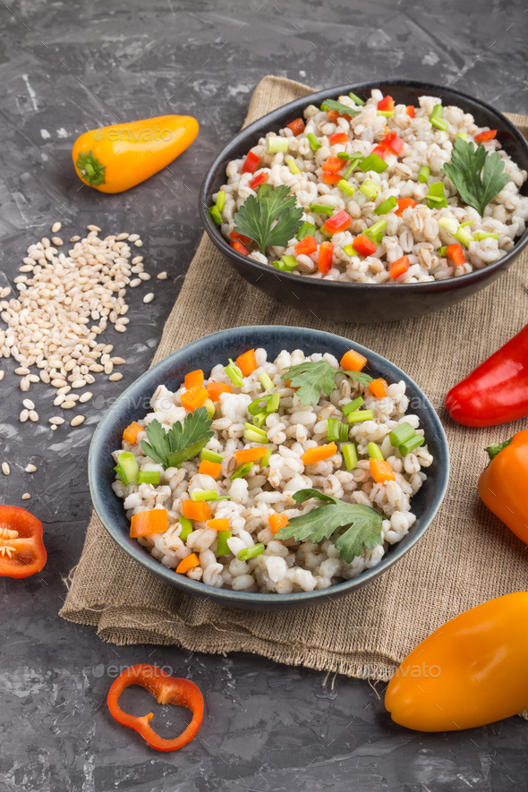 Pearl barley porridge with vegetables in blue ceramic bowls. Side view ...