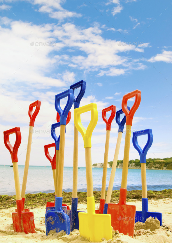 Colourful childrens' spades stuck in sand on beach. Stock Photo by Mint ...
