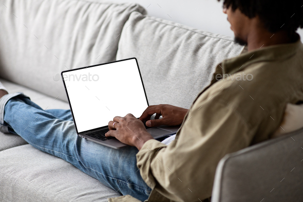 Black Man Using Laptop Computer With Blank Screen While Sitting On ...